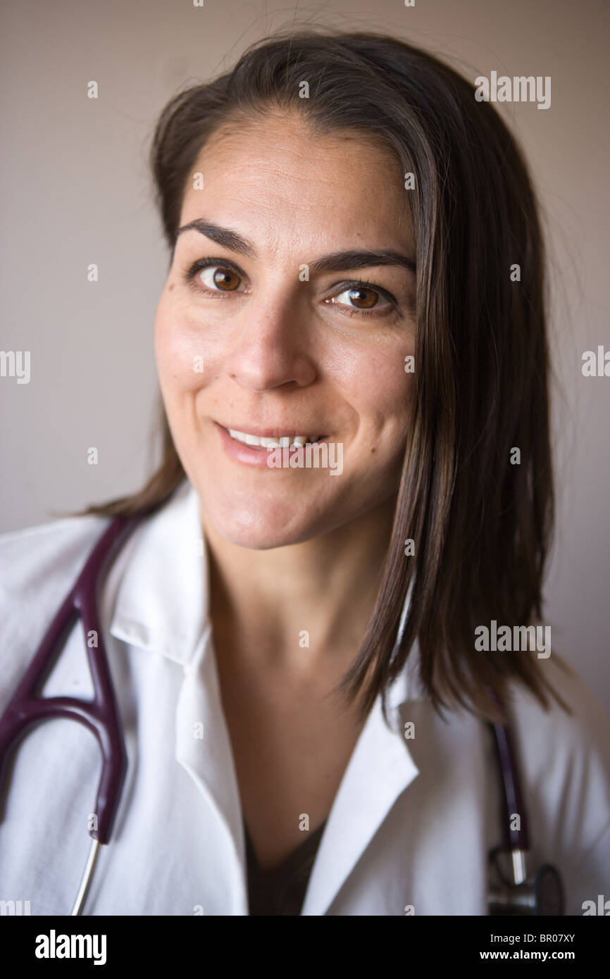closeup of Hispanic doctor wearing white coat and stethoscope, female ...