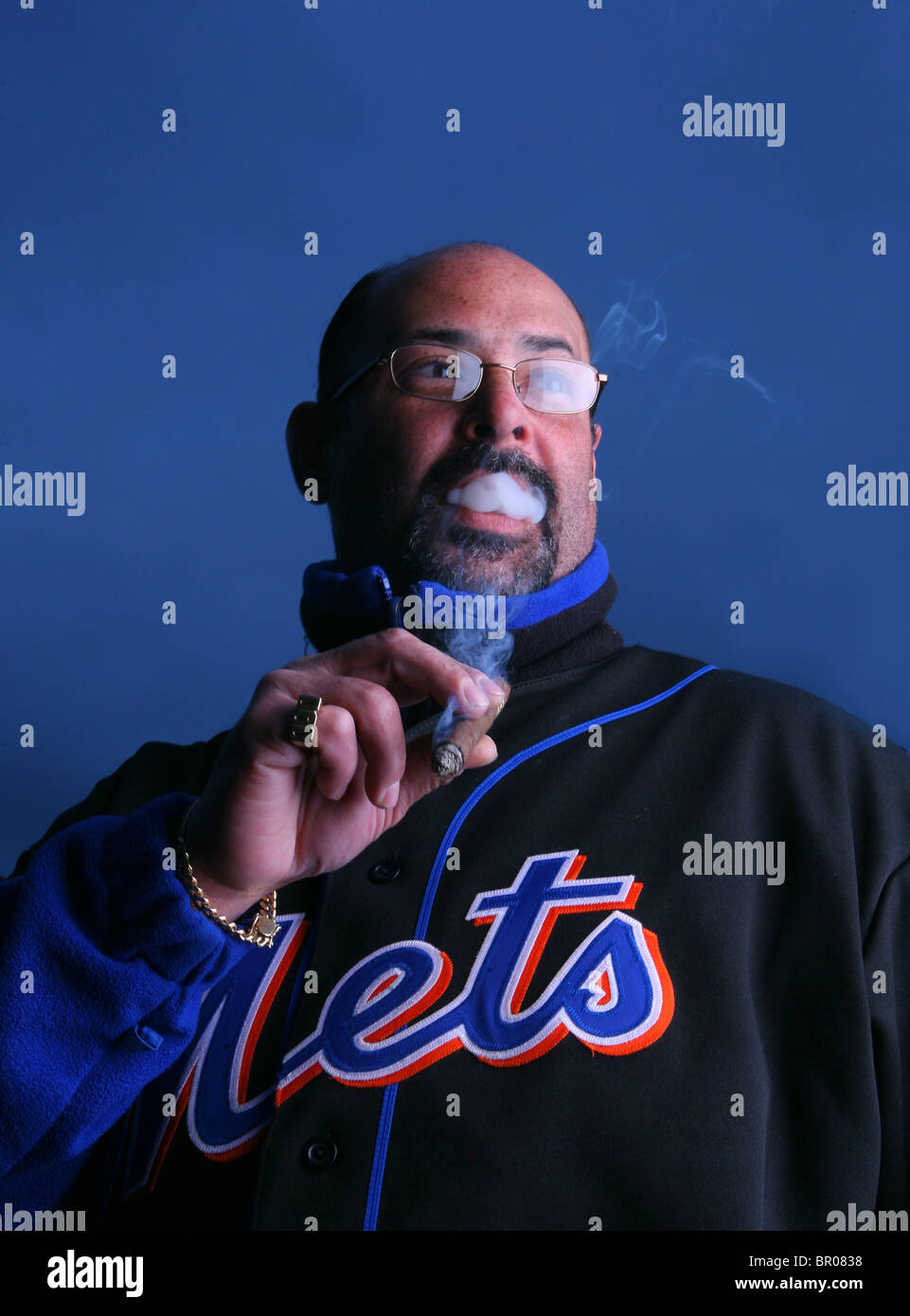 A baseball fan smokes a cigar on baseball's opening day in New York ...
