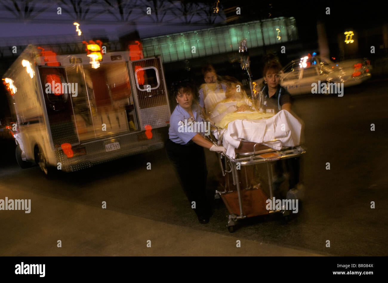 Doctors wheel a patient out of the emergency vehicle into the hospital ...