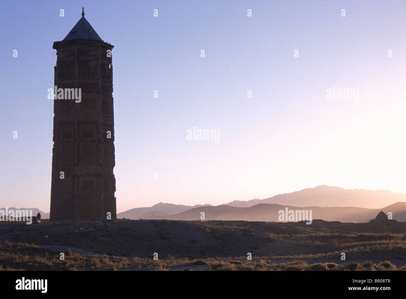 Dawn light silhouettes a slender brick minaret outside of Ghazni ...