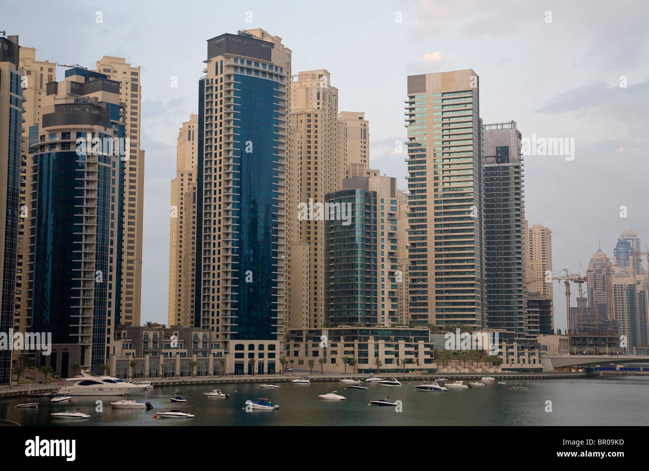 UAE, Dubai. Modern buildings tower over boats in Marina Bay Stock Photo ...