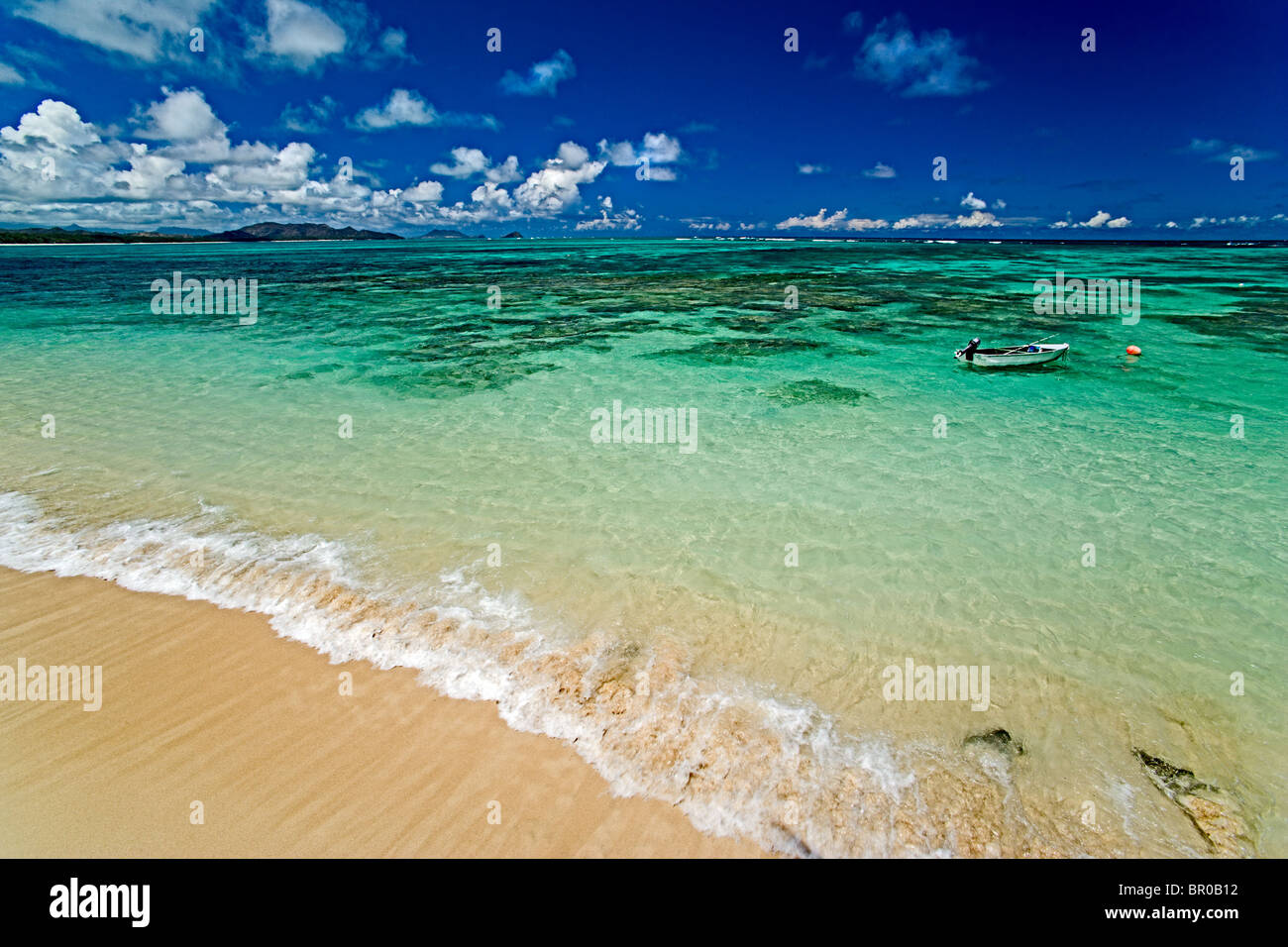 tropical beach with small fishing boat in Hawaii with azure water and ...
