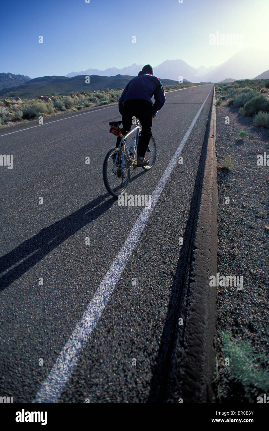 A male road biker rides down a highway Stock Photo - Alamy