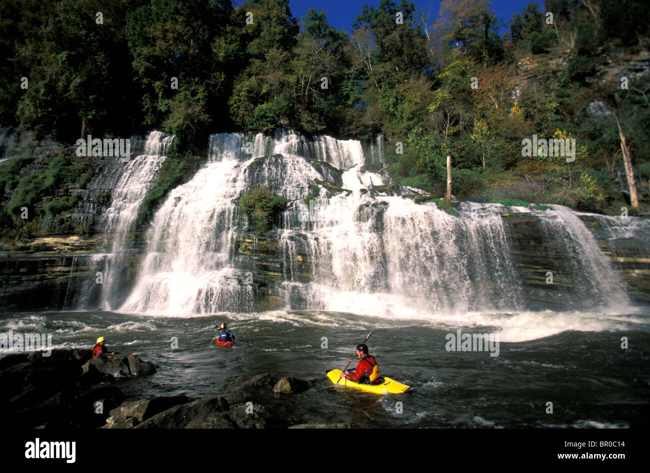 A father and his children kayak in a river by a waterfall Stock Photo ...
