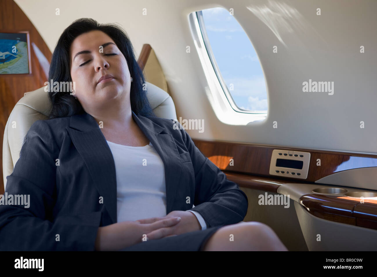 Hispanic businesswoman sleeping on private jet Stock Photo - Alamy