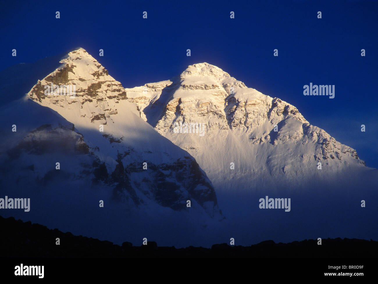 A massive snow covered mountain shining with alpine glow at sunset ...