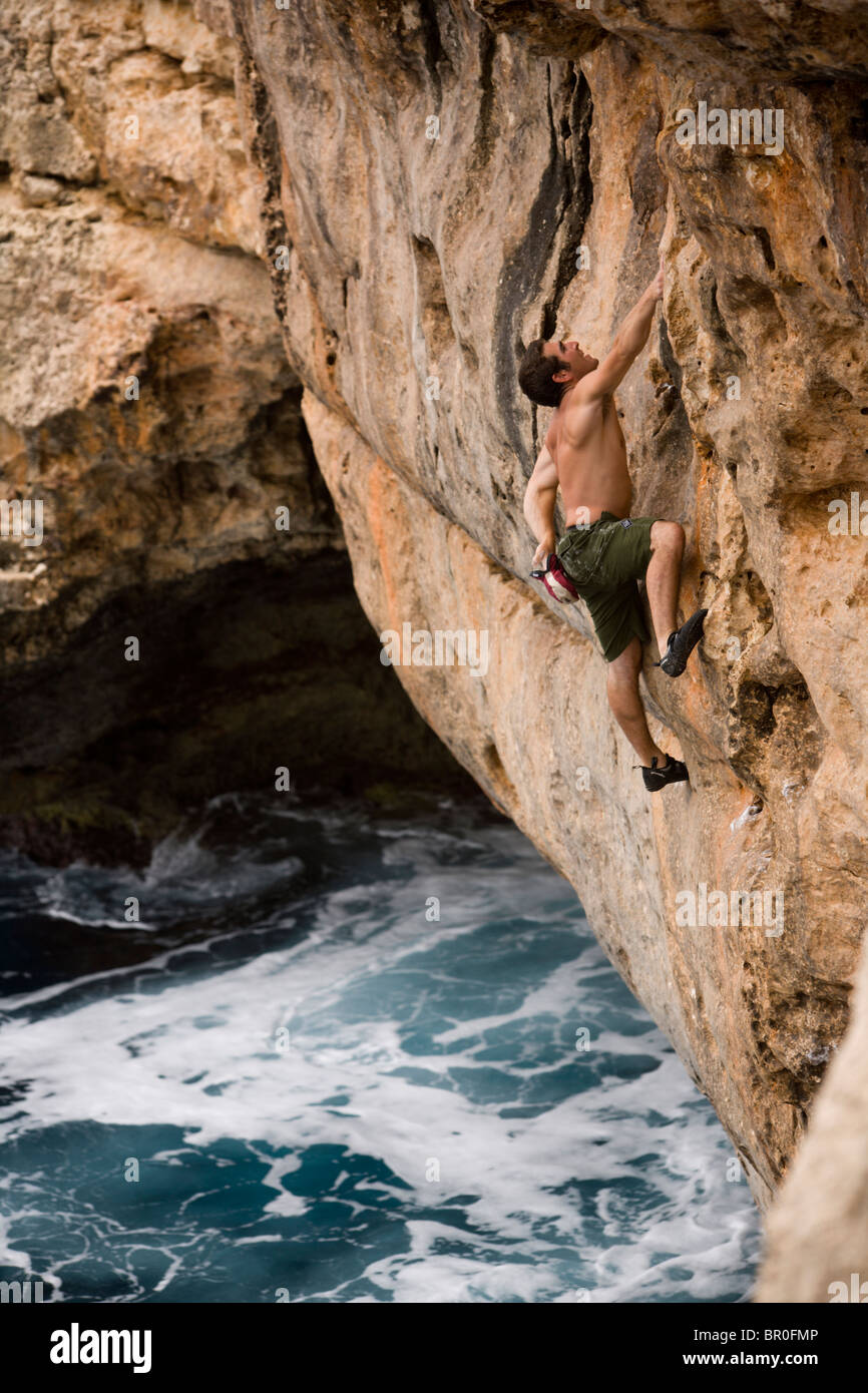 A man deep water soloing / rock climbing Stock Photo - Alamy
