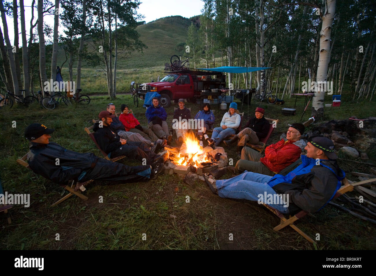 group sitting around campfire, Colorado Stock Photo - Alamy