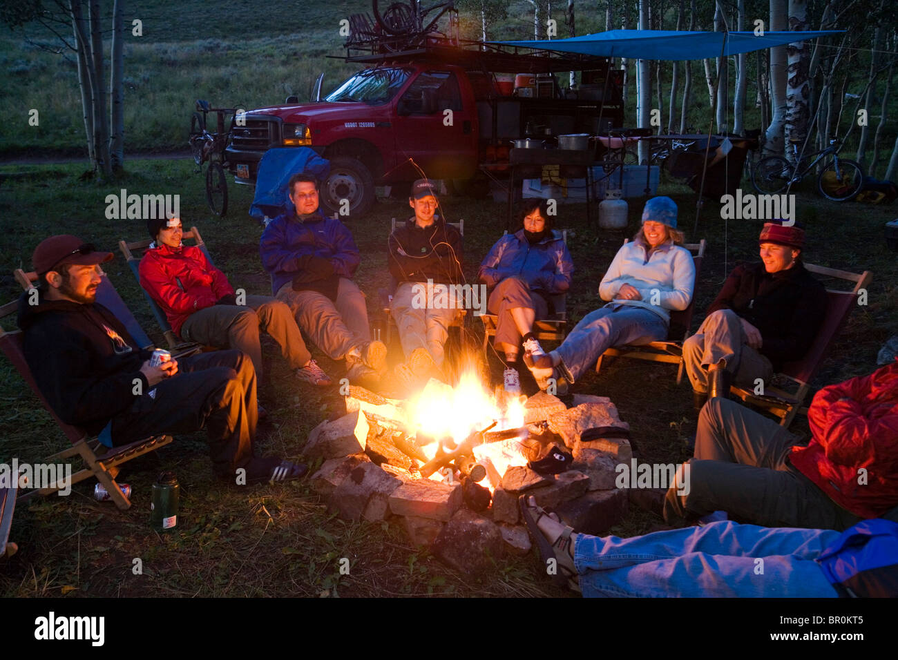 group sitting around campfire, Colorado Stock Photo - Alamy