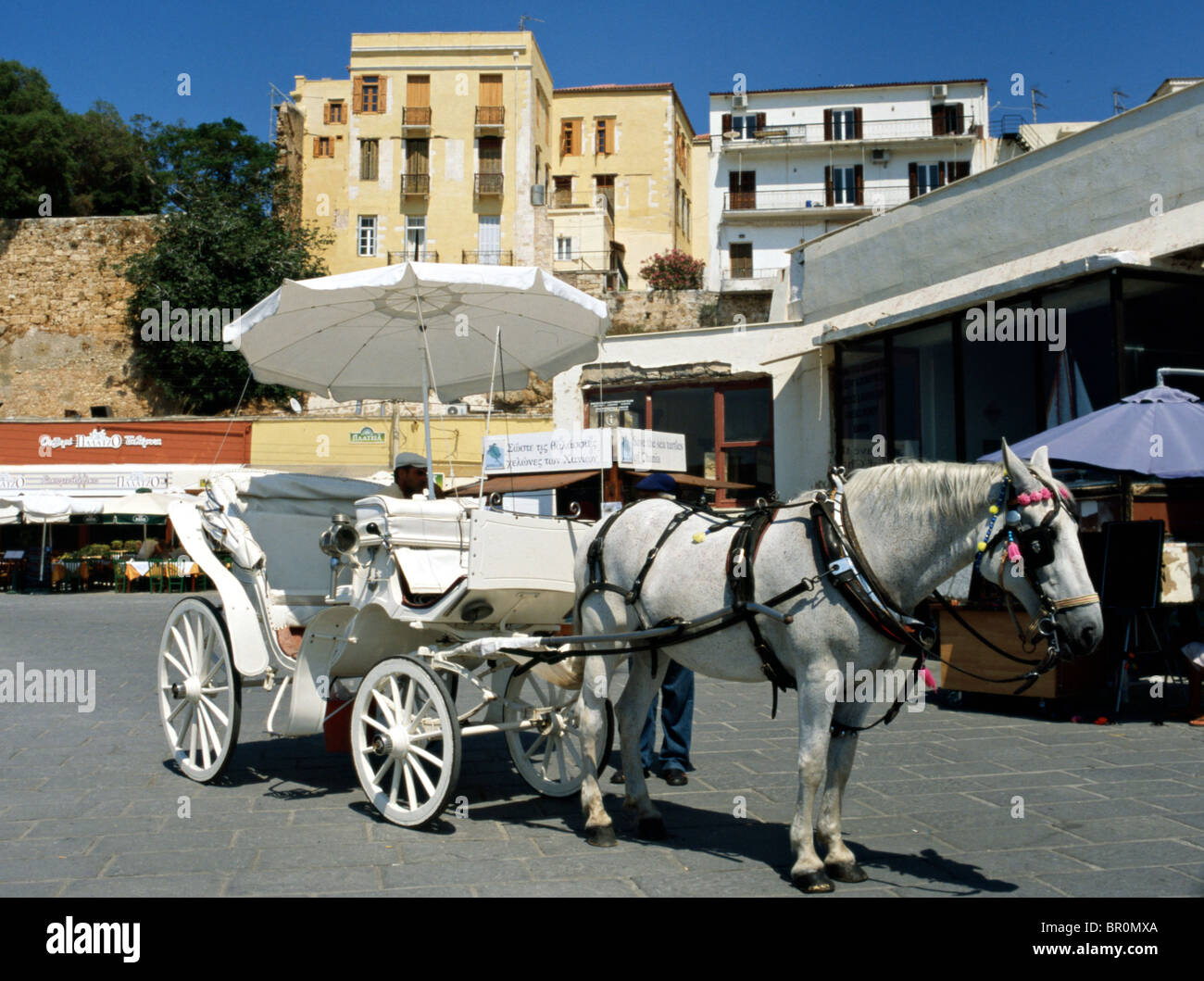 A horse and carriage taxi waiting in the historic harbour area of ...