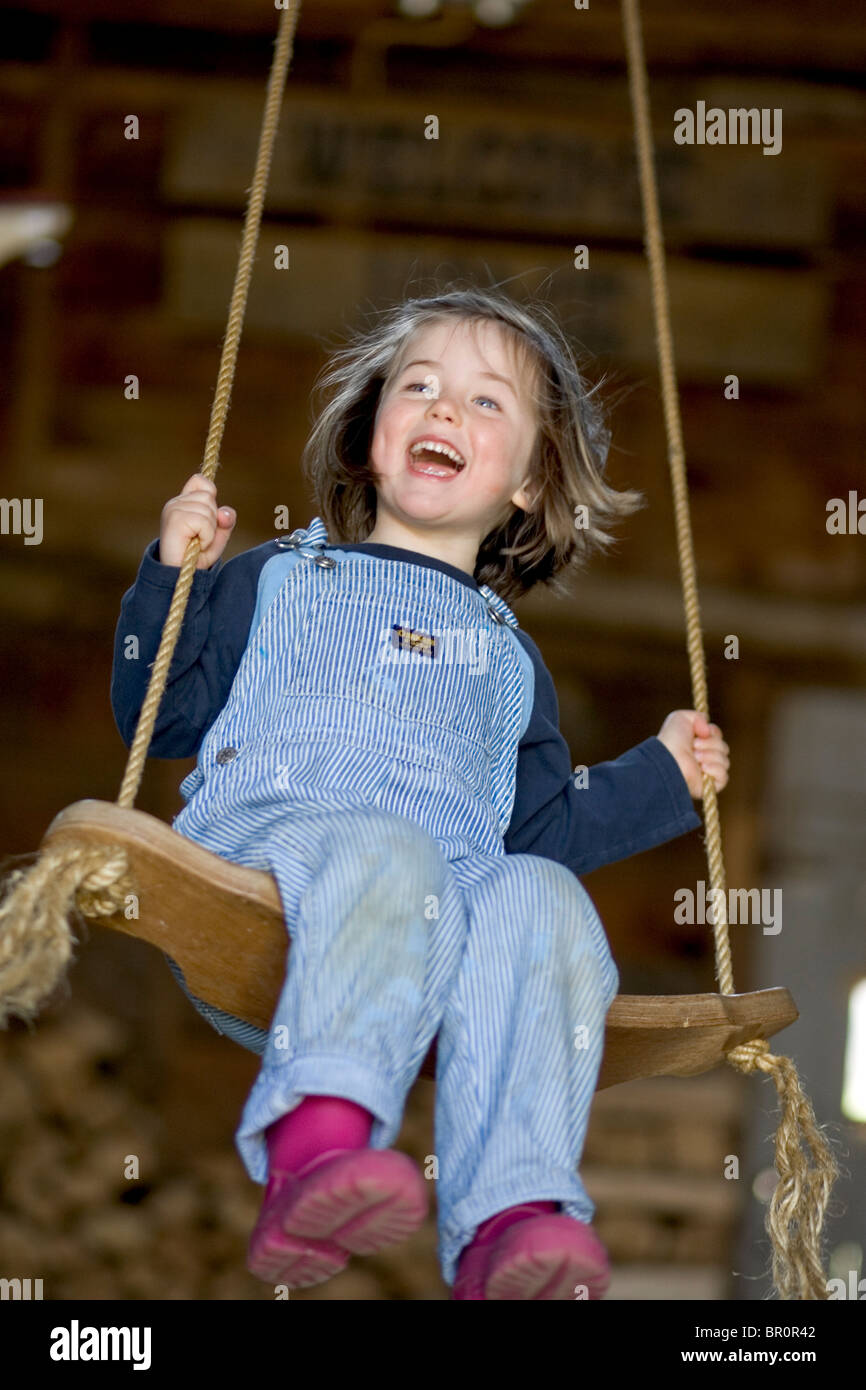 A child plays on a swing inside of an old barn in Yarmouth, Maine Stock ...