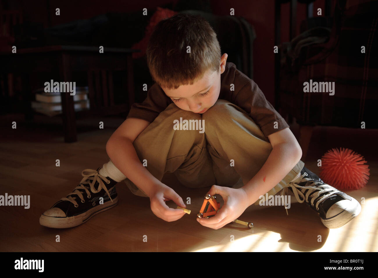 A young boy sits on the floor playing with toys in Boise, Idaho Stock ...