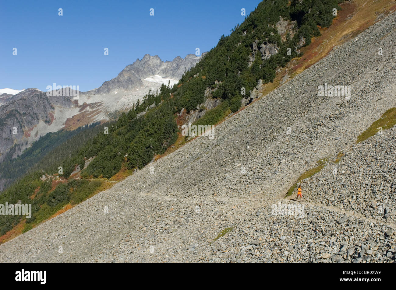 Woman running in boulder field on mountain trail Stock Photo - Alamy