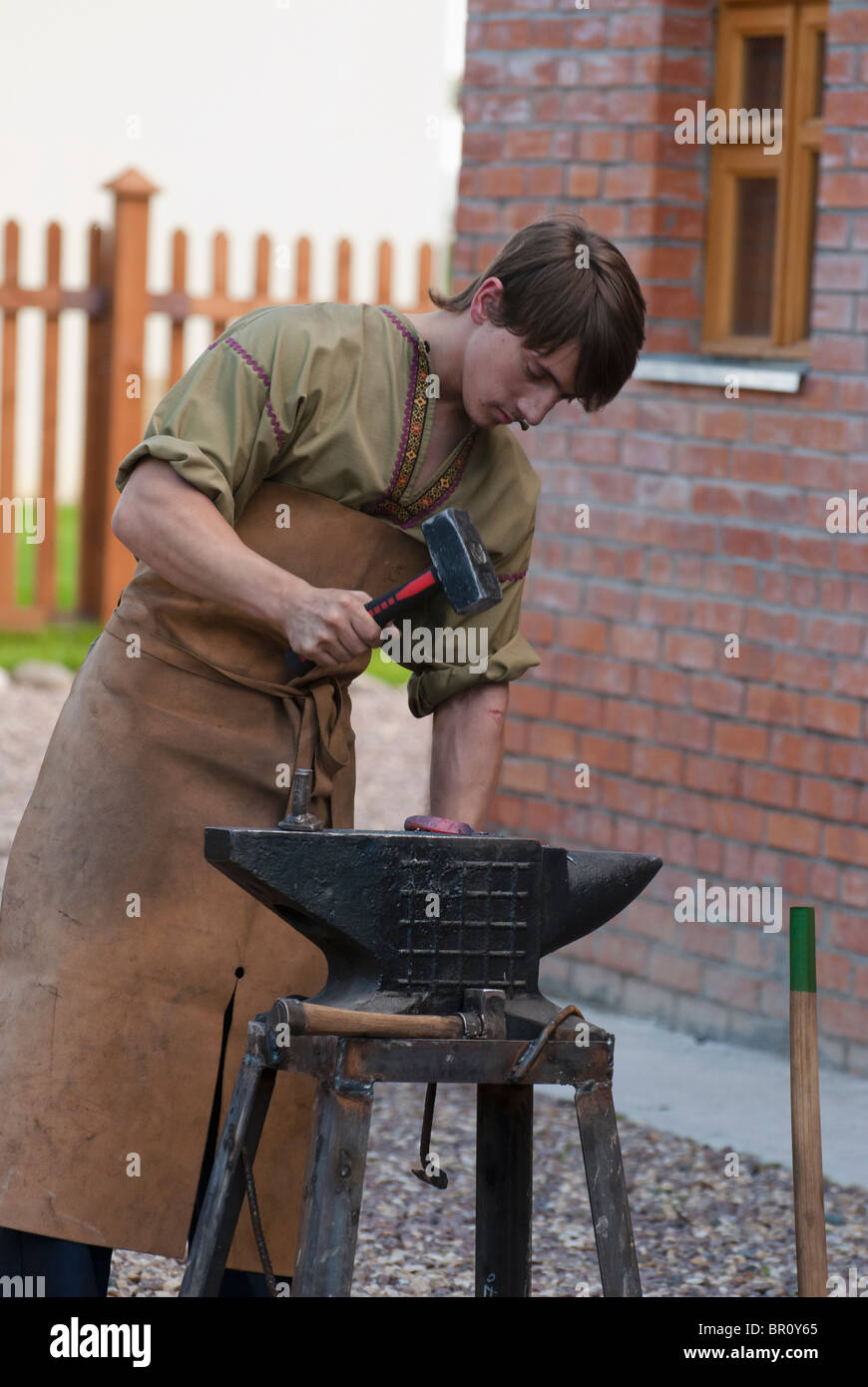 Young smith forging the iron item Stock Photo - Alamy