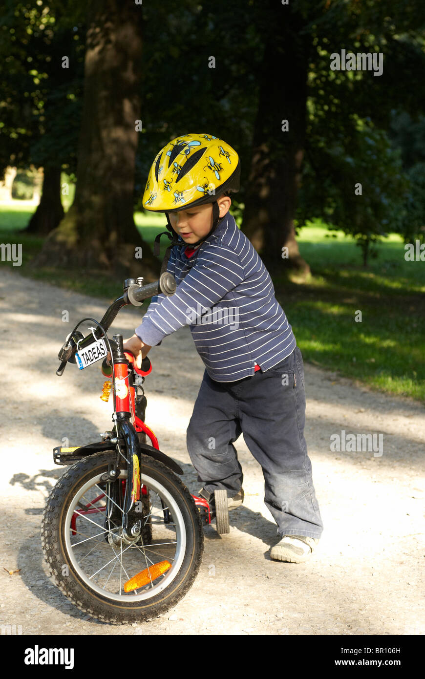Boy Learning to Ride Bicycle with stabilizing wheel bike Stock Photo ...