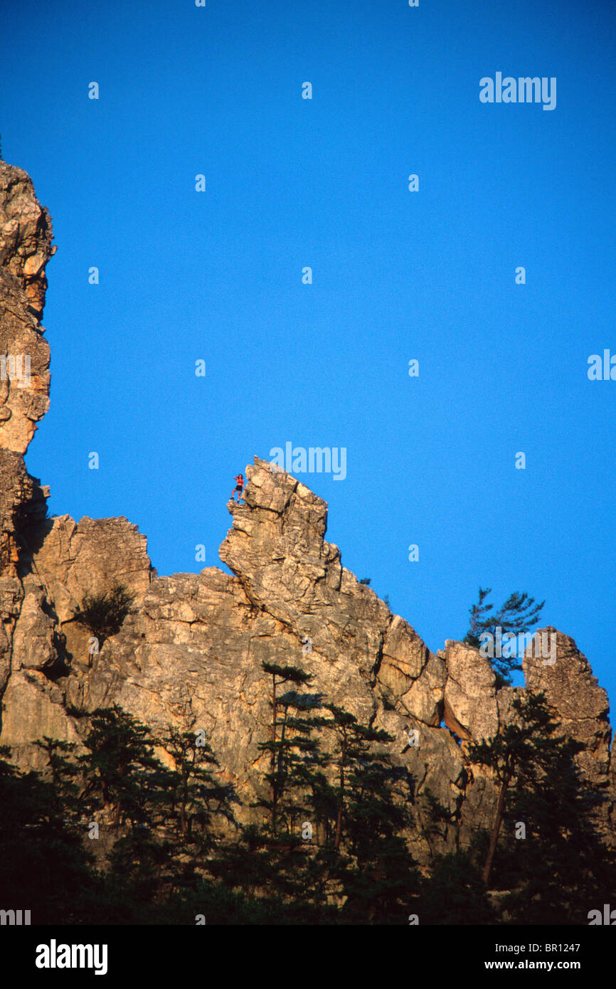 Female climber atop a rocky promontory at Seneca Rocks, West Virginia ...