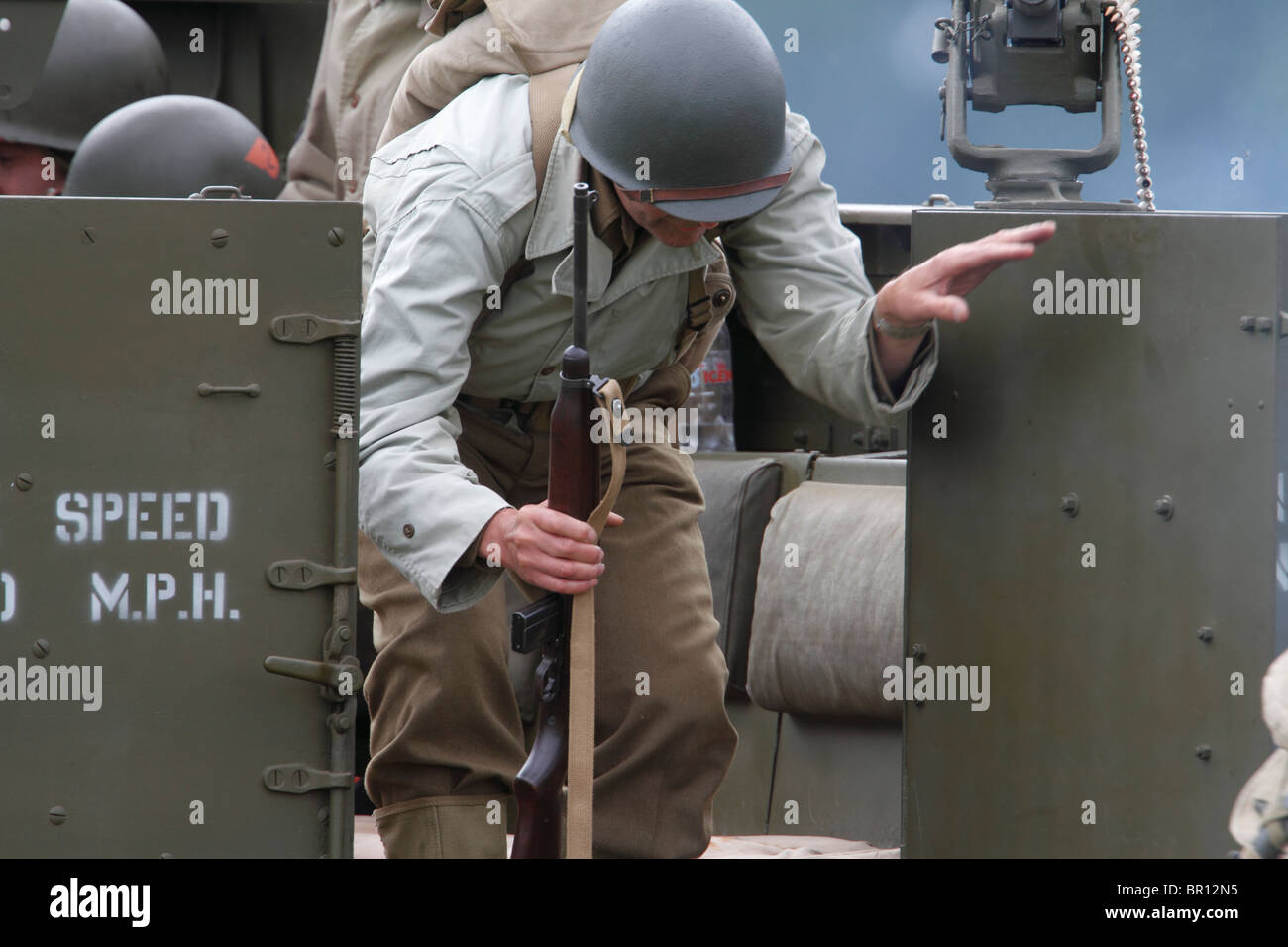 WWII re-enactment. Infantry dismounting the APC. A US M3A1 Halftrack ...