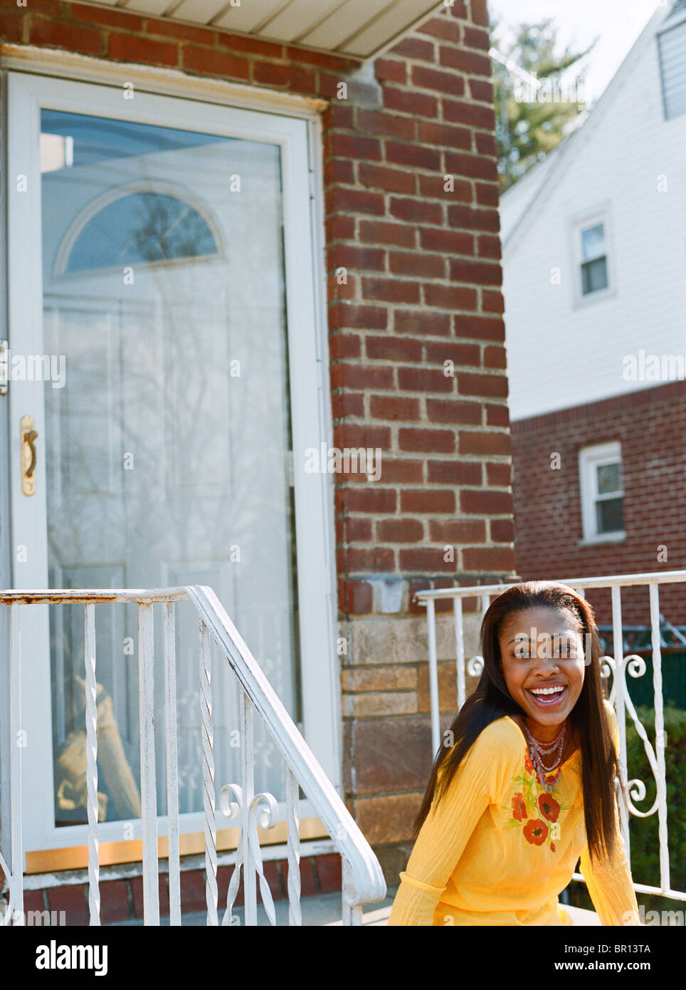 Woman sitting on front stoop Stock Photo - Alamy
