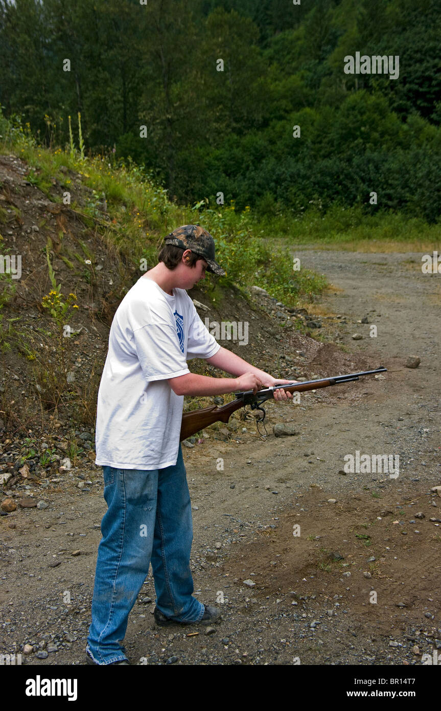 Teenager with hearing protection loading a rifle hi-res stock ...