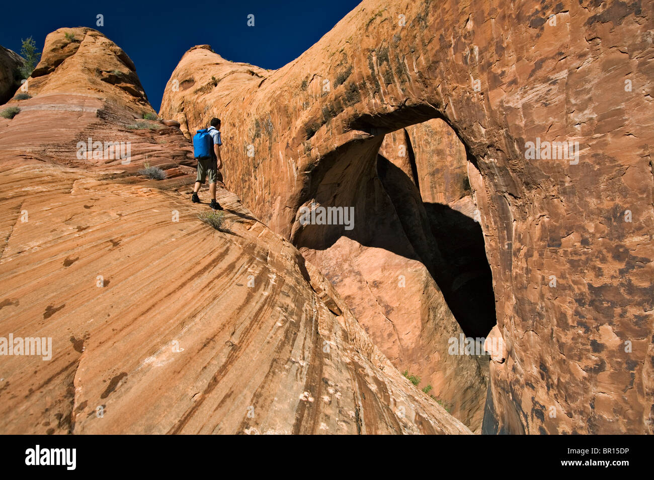 A man hiking next to a sandstone arch, Moab, Utah Stock Photo - Alamy