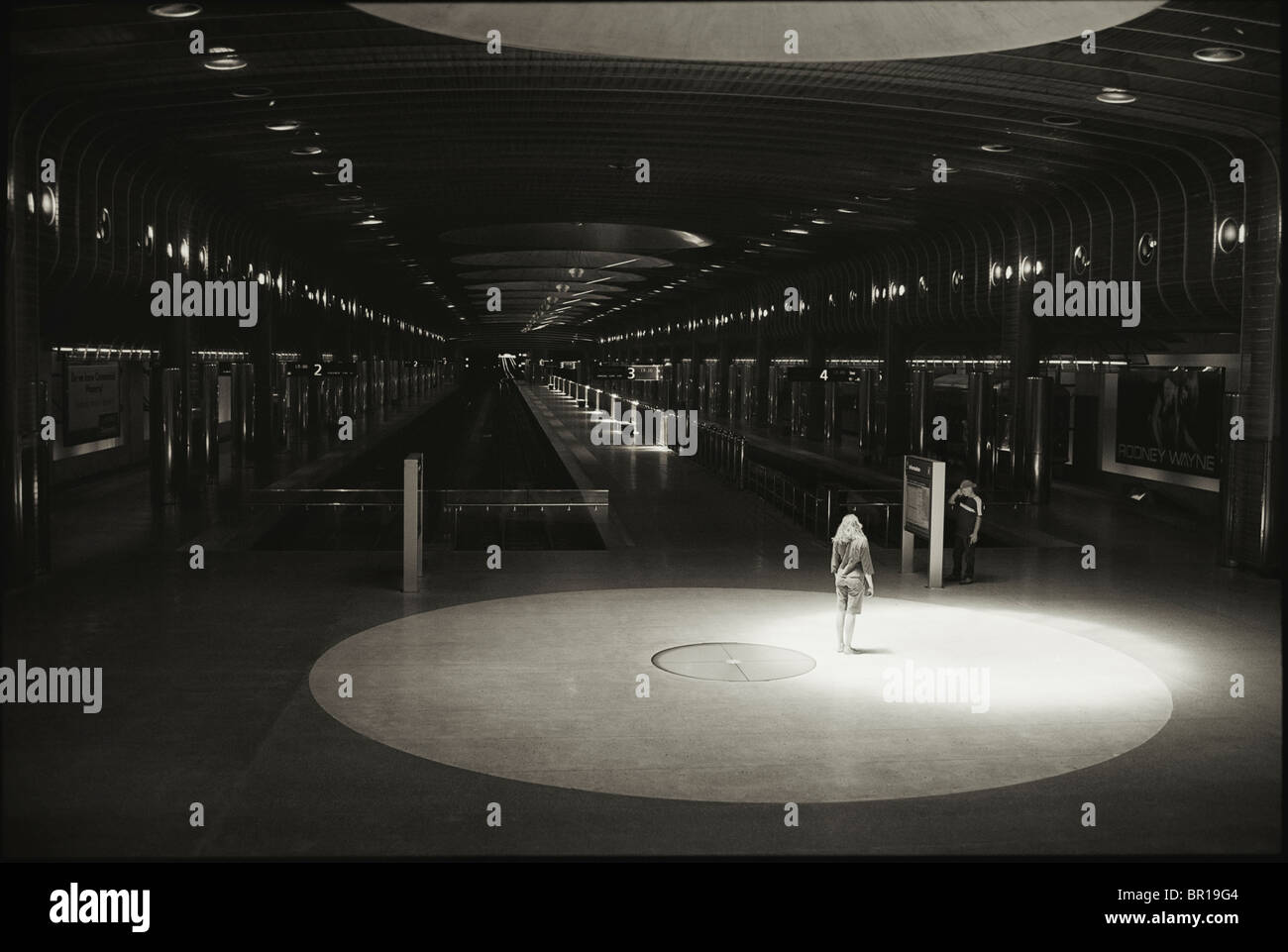 A young woman stands lit by a skylight in the cavernous Auckland Train ...