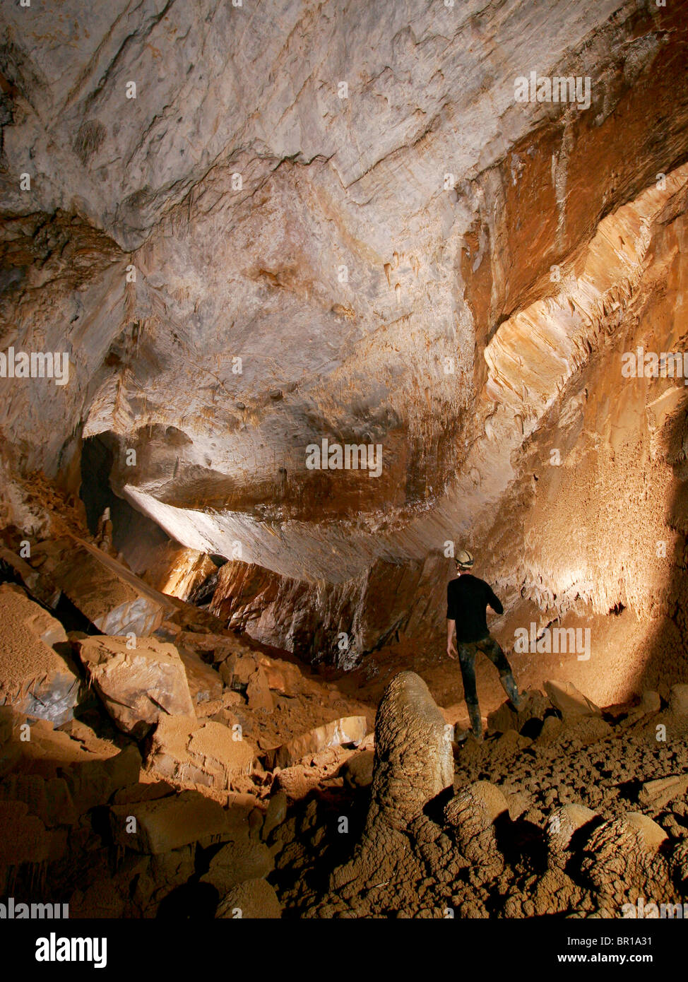 A cave explorer adds scale to a passage in a cave in Mulu National Park ...