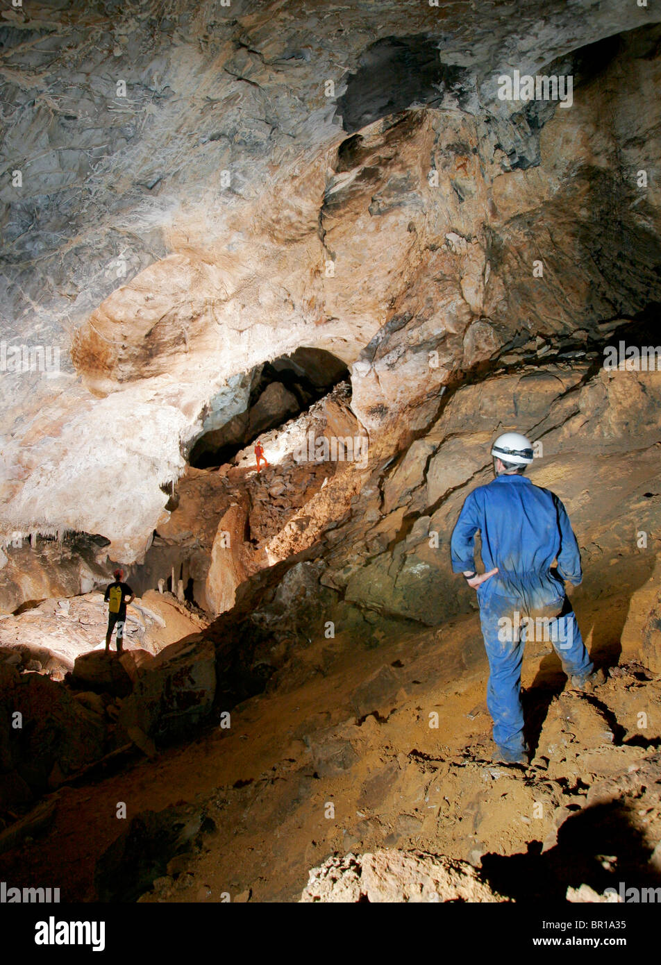 Cave explorers illuminate a passage in a cave in Mulu National Park ...