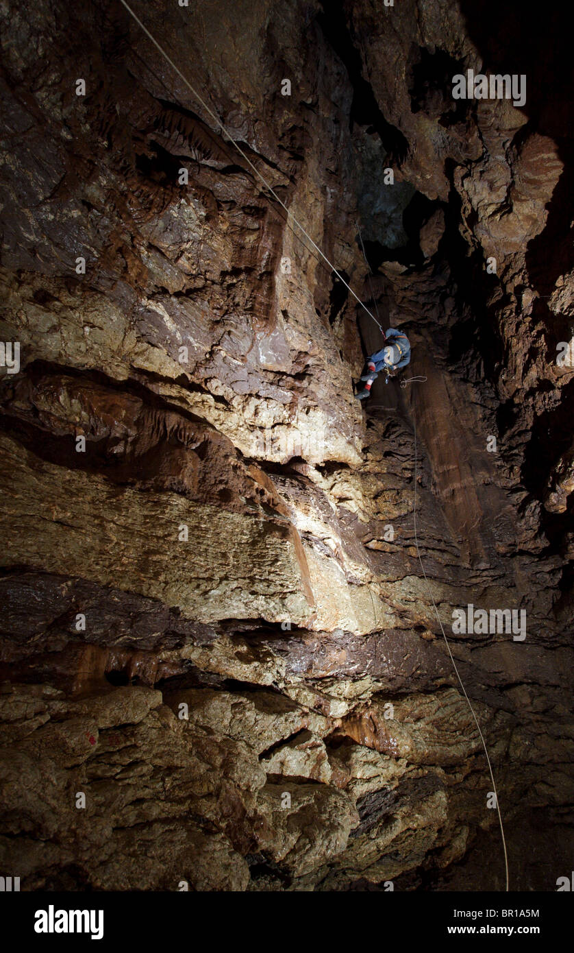 Cave explorer descends a tensioned line into a chamber underground in a ...