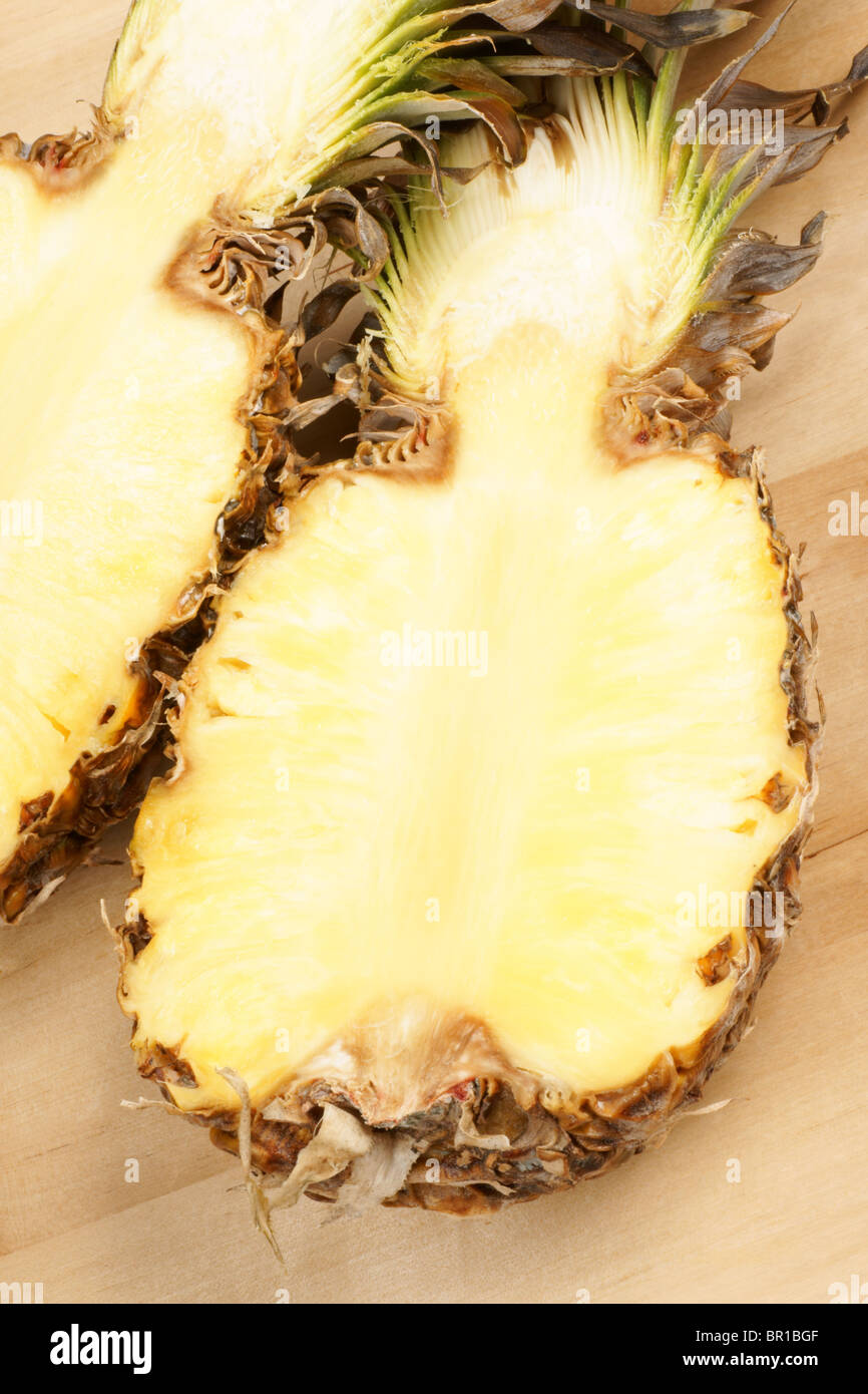 Fresh half cut pineapple over a wooden background Stock Photo - Alamy