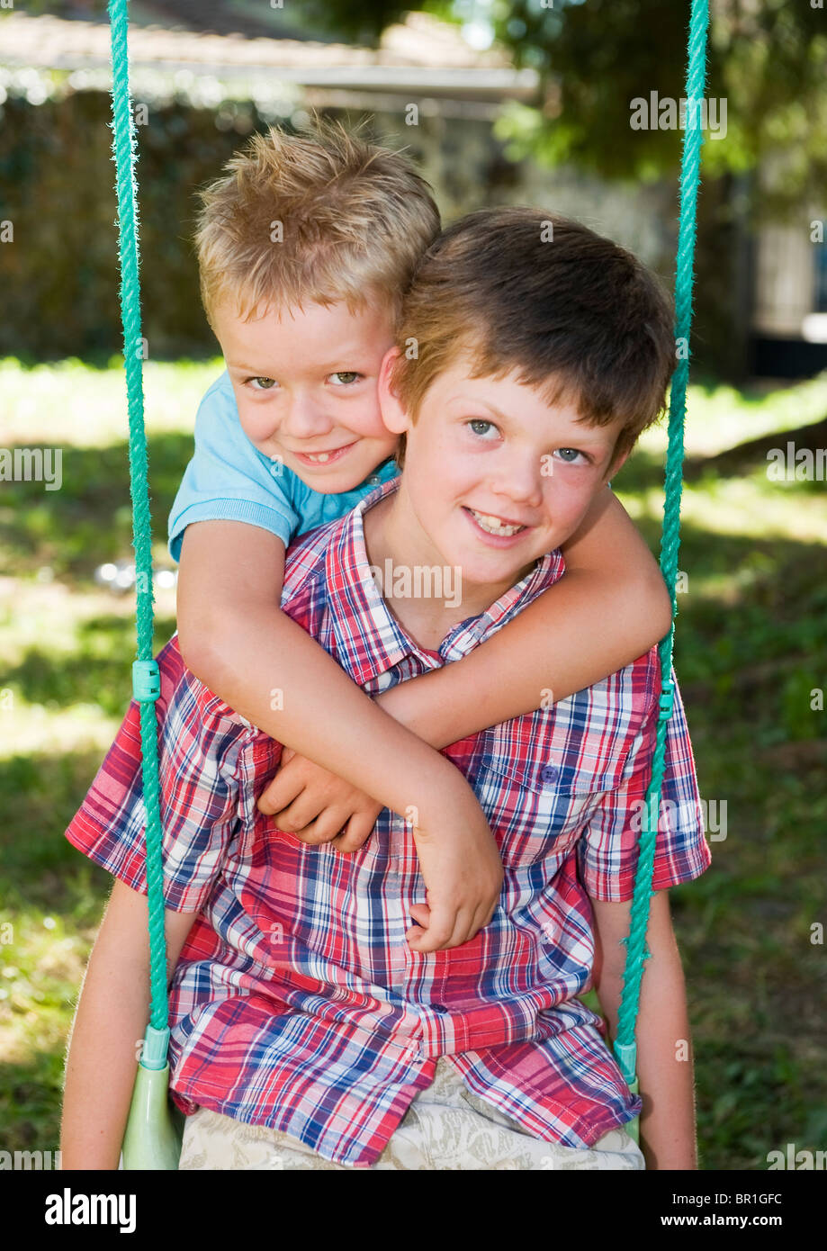 Two young Boys Playing on a Garden Swing Stock Photo - Alamy