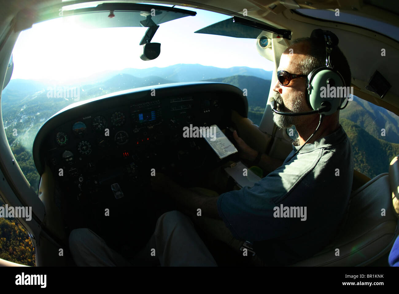Male pilot at the controls of a Cessna 182 above the Appalachian ...