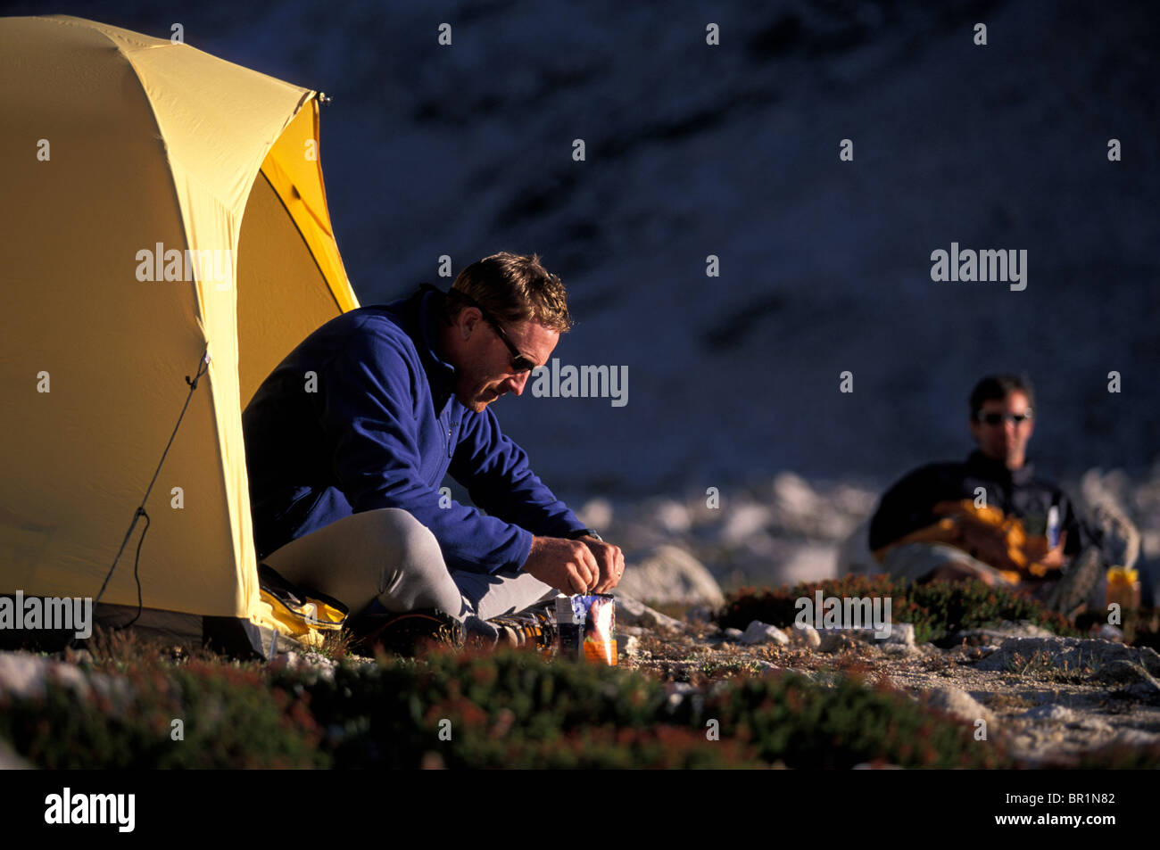 Man making breakfast outside of his tent in eastern Sierra Nevada ...