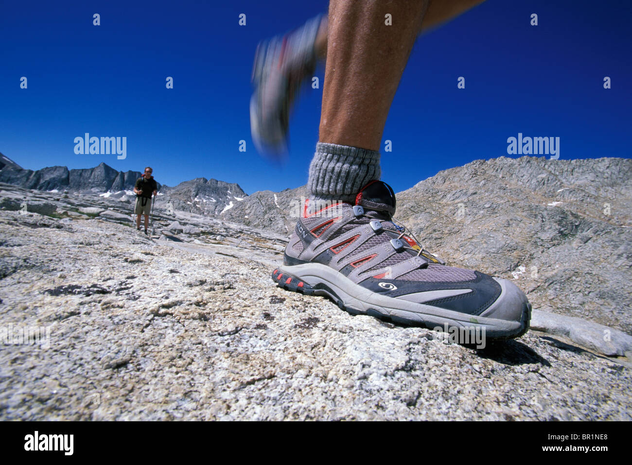 Feet with trail running shoes hiking by in eastern Sierra Nevada ...