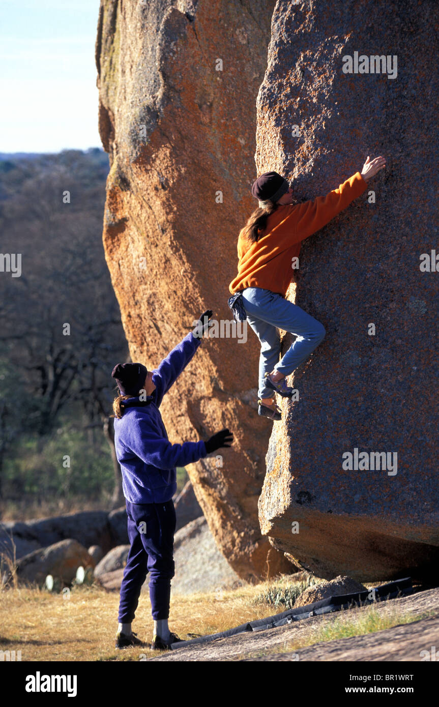 A climber spotting another climber while bouldering near Austin, Texas ...