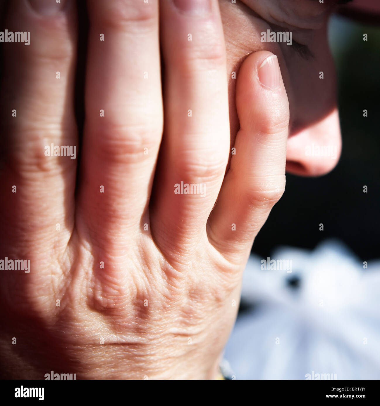 A womans hands against the side of her face Stock Photo - Alamy