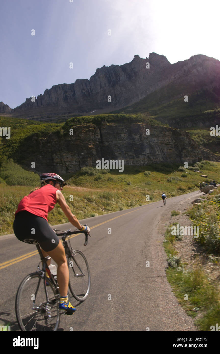 Cyclists climb a hill with a mountain in the distance Stock Photo - Alamy