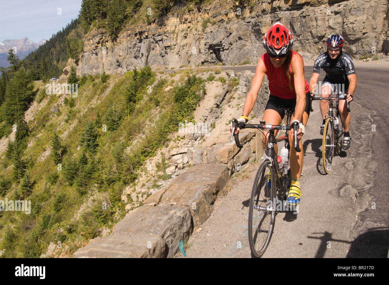 Cyclists climb a hill with a mountain in the distance Stock Photo - Alamy
