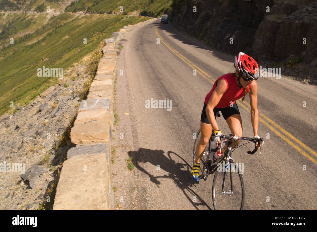 Cyclists climb a hill with a mountain in the distance Stock Photo - Alamy