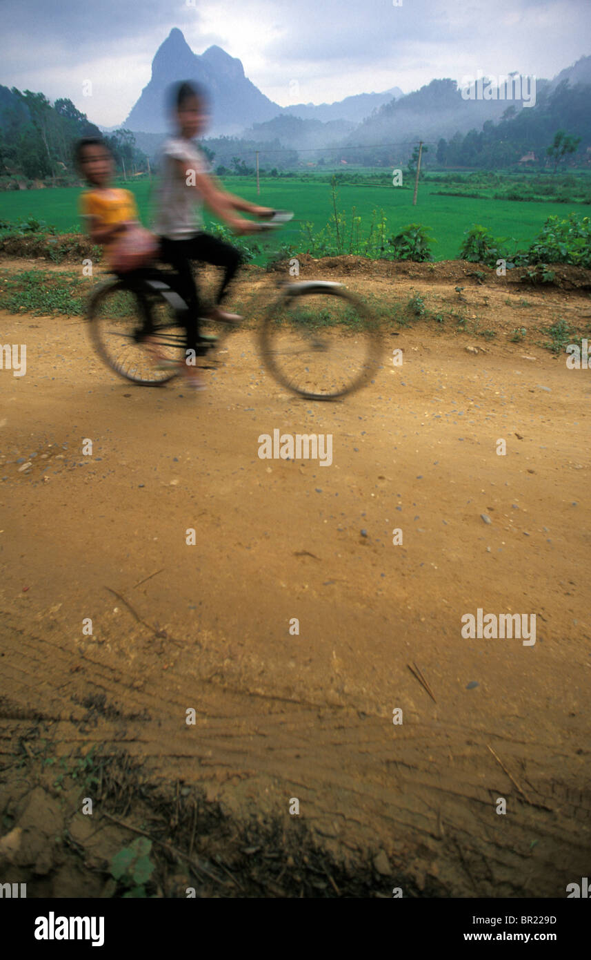Two children riding a bike on a dirt road near Bac Ha, Vietnam Stock ...