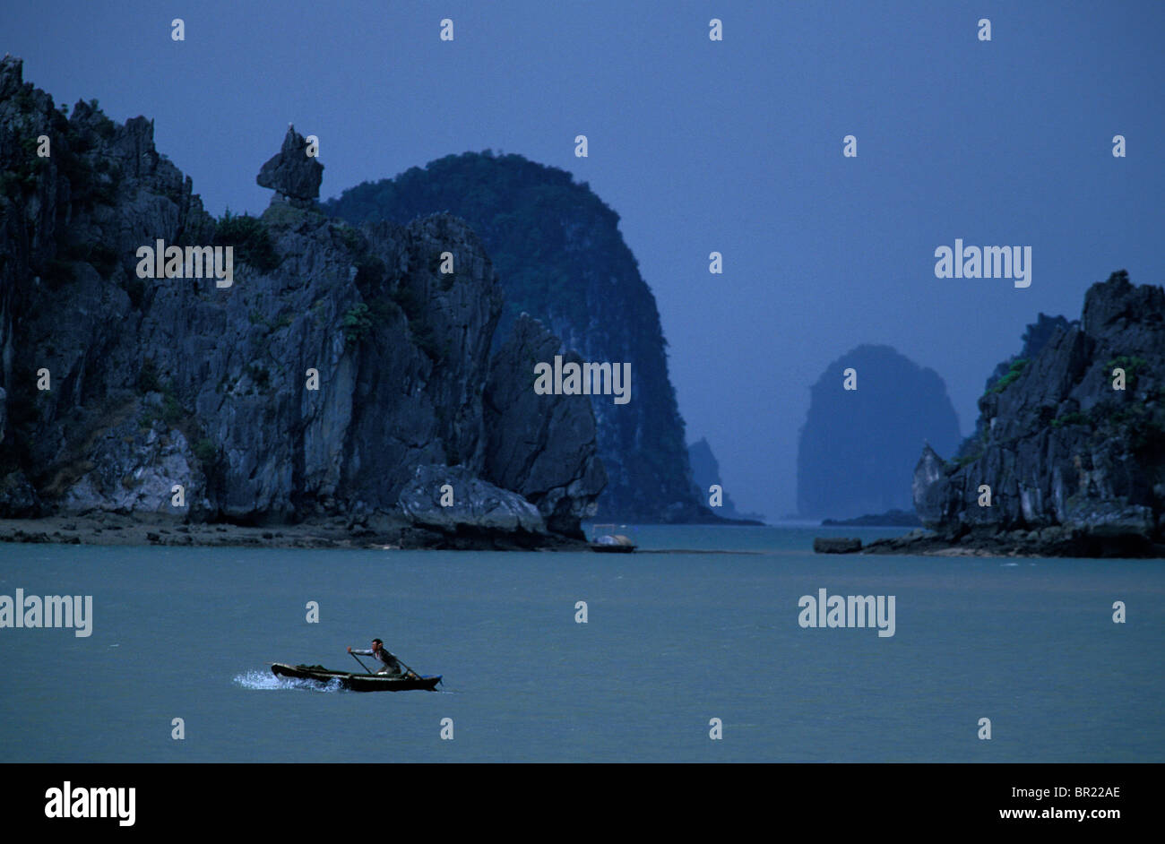 A man rowing his boat in Halong Bay in northern Vietnam Stock Photo - Alamy