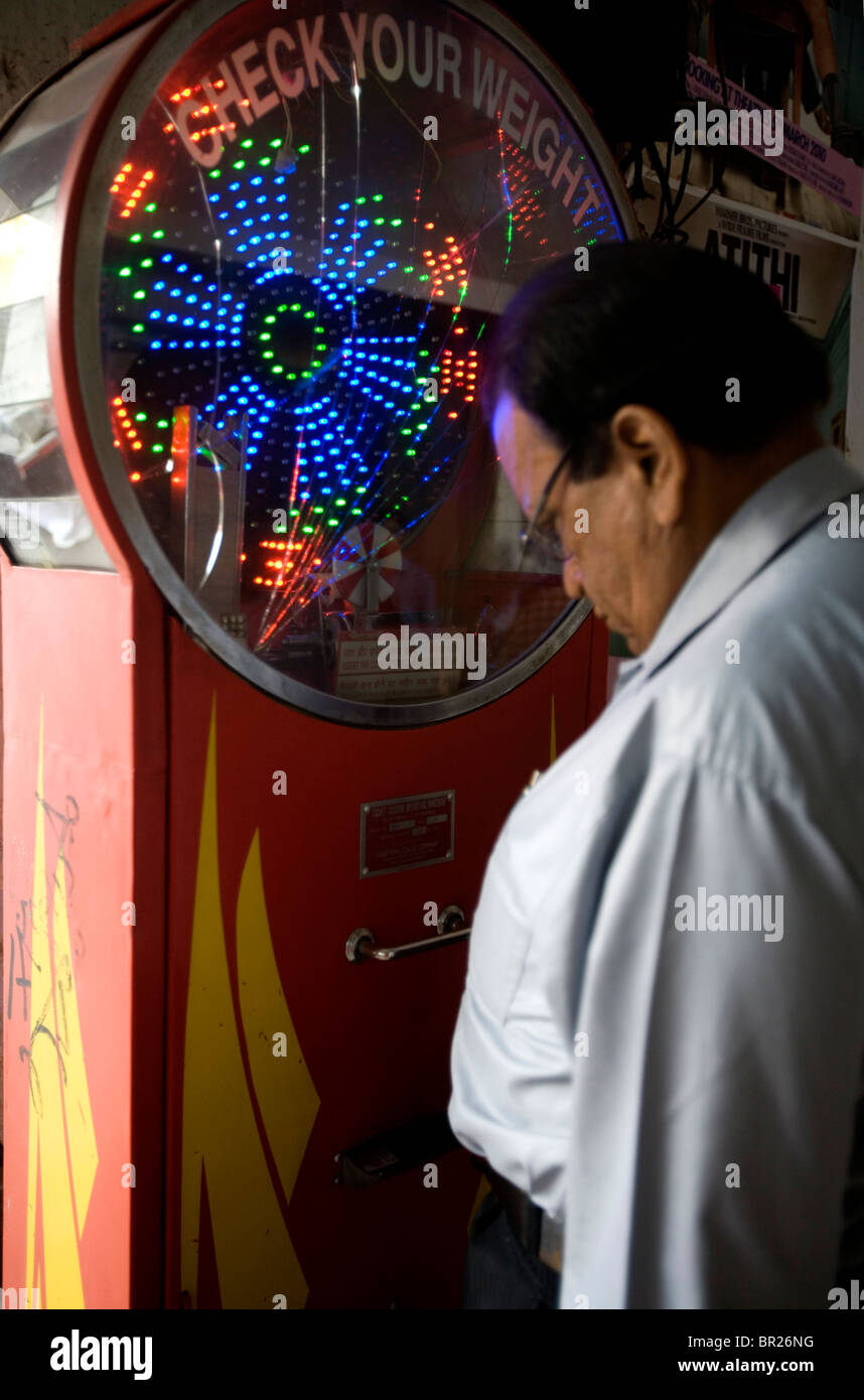 Indian man checking his weight on a public scale, Delhi, India Stock ...