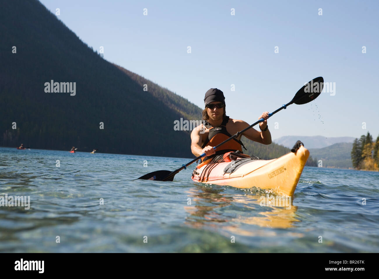 Solo man kayaks through mountain lake Stock Photo - Alamy