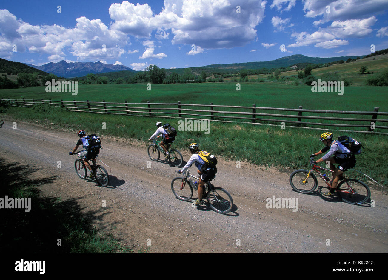 Team mountain biking on a dirt road in an adventure race in Telluride ...