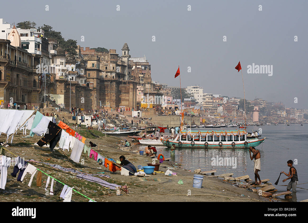 River Ganges with ancient buildings on the bathing ghats at Varanasi ...