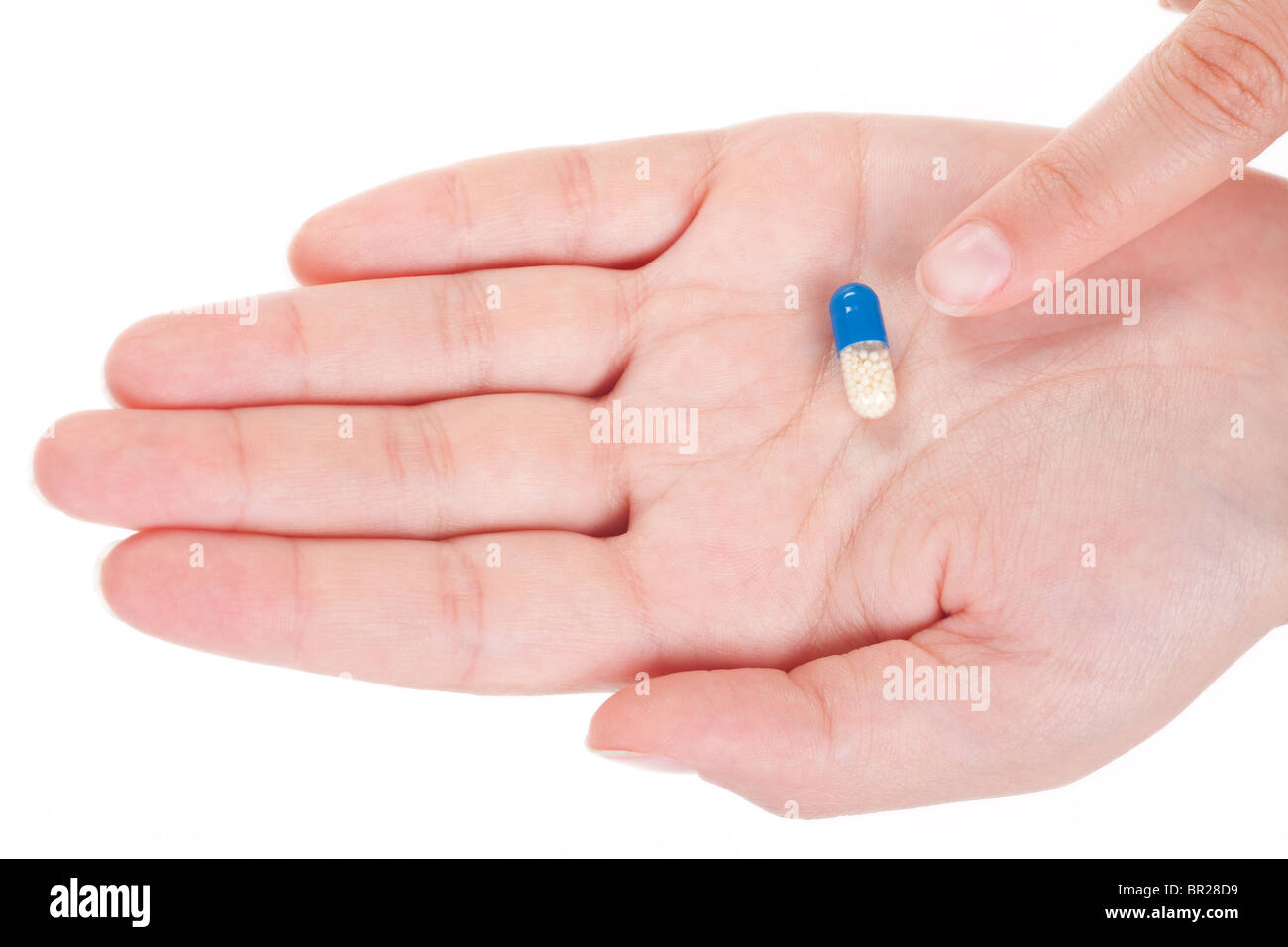 blue medical capsule in a female hand, isolated Stock Photo - Alamy