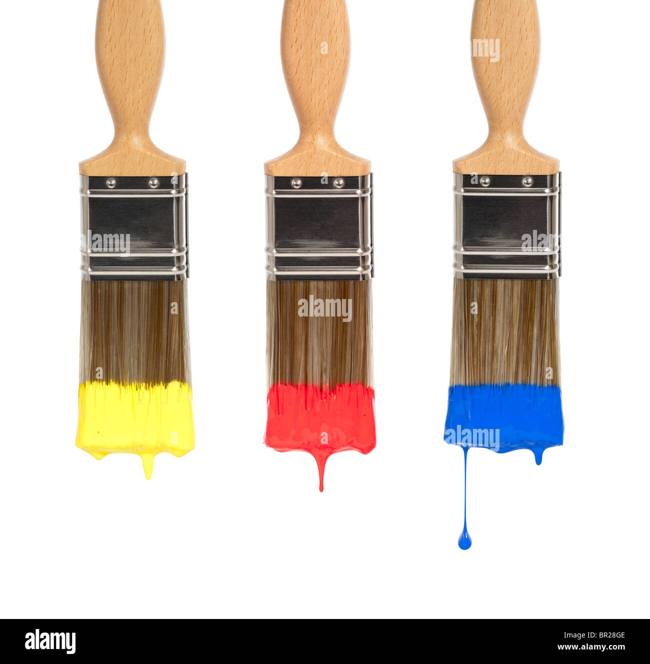 Three decorators paint brushes dripping with different coloured paints ...