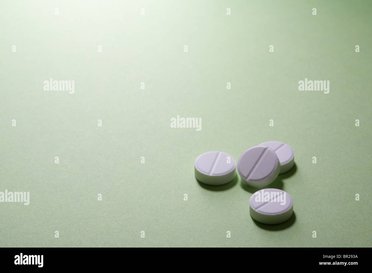 four medical pills, isolated on green background Stock Photo - Alamy