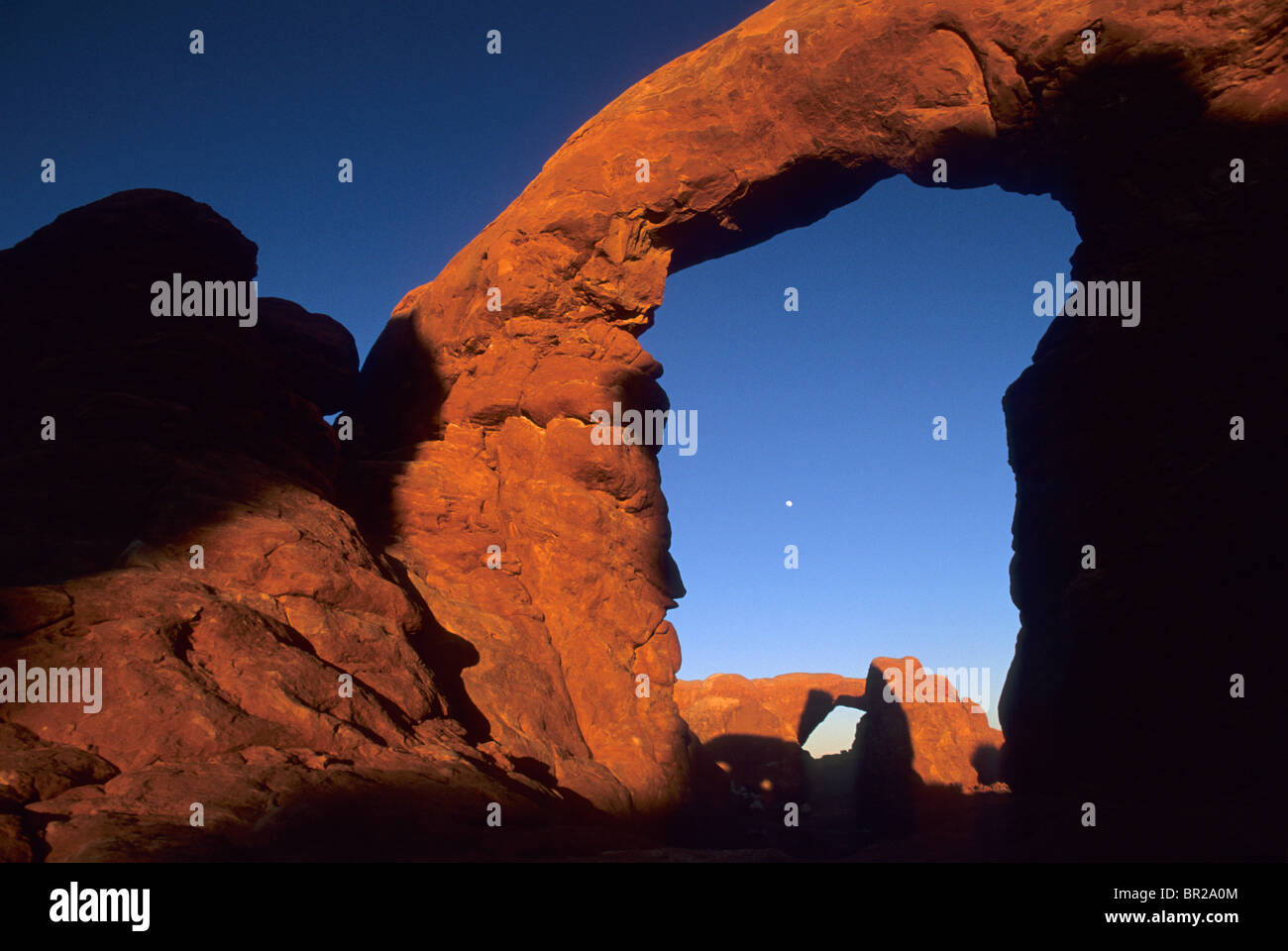 View of Turret Arch through double arch as moon rises, Arches National ...