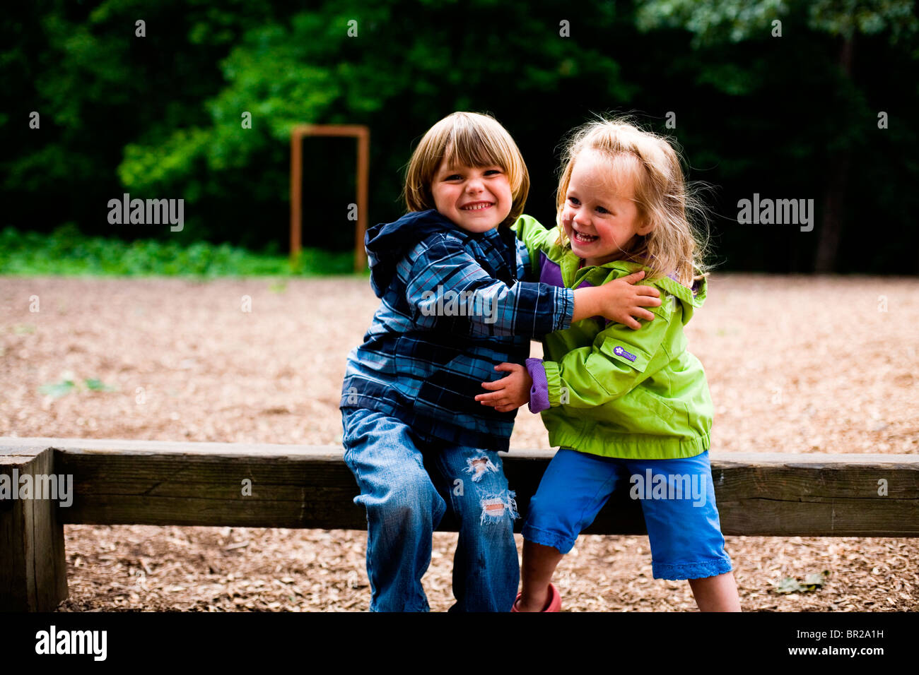 Two small kids hug for a photo in the playground Stock Photo - Alamy