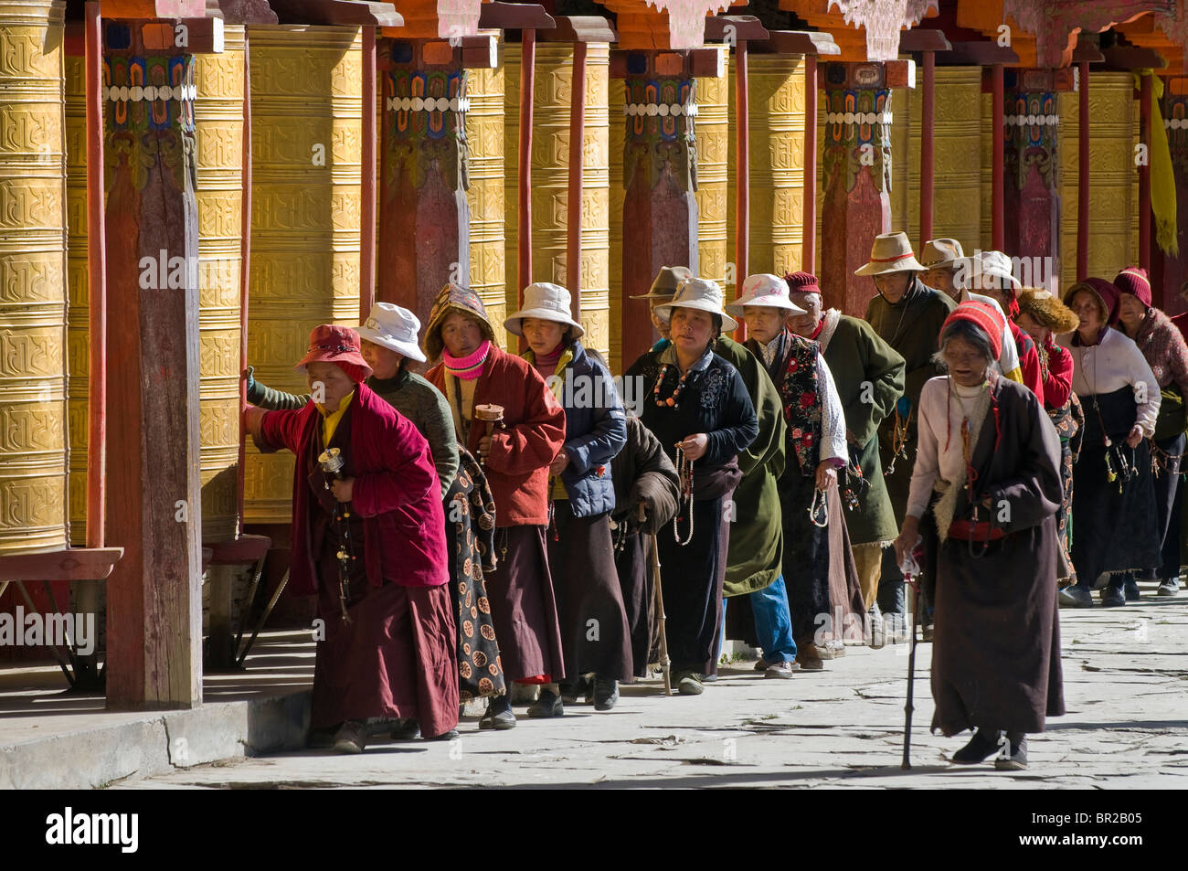 Tibetan Buddhist pilgrims turn golden prayer wheels at Huiyuan Temple ...